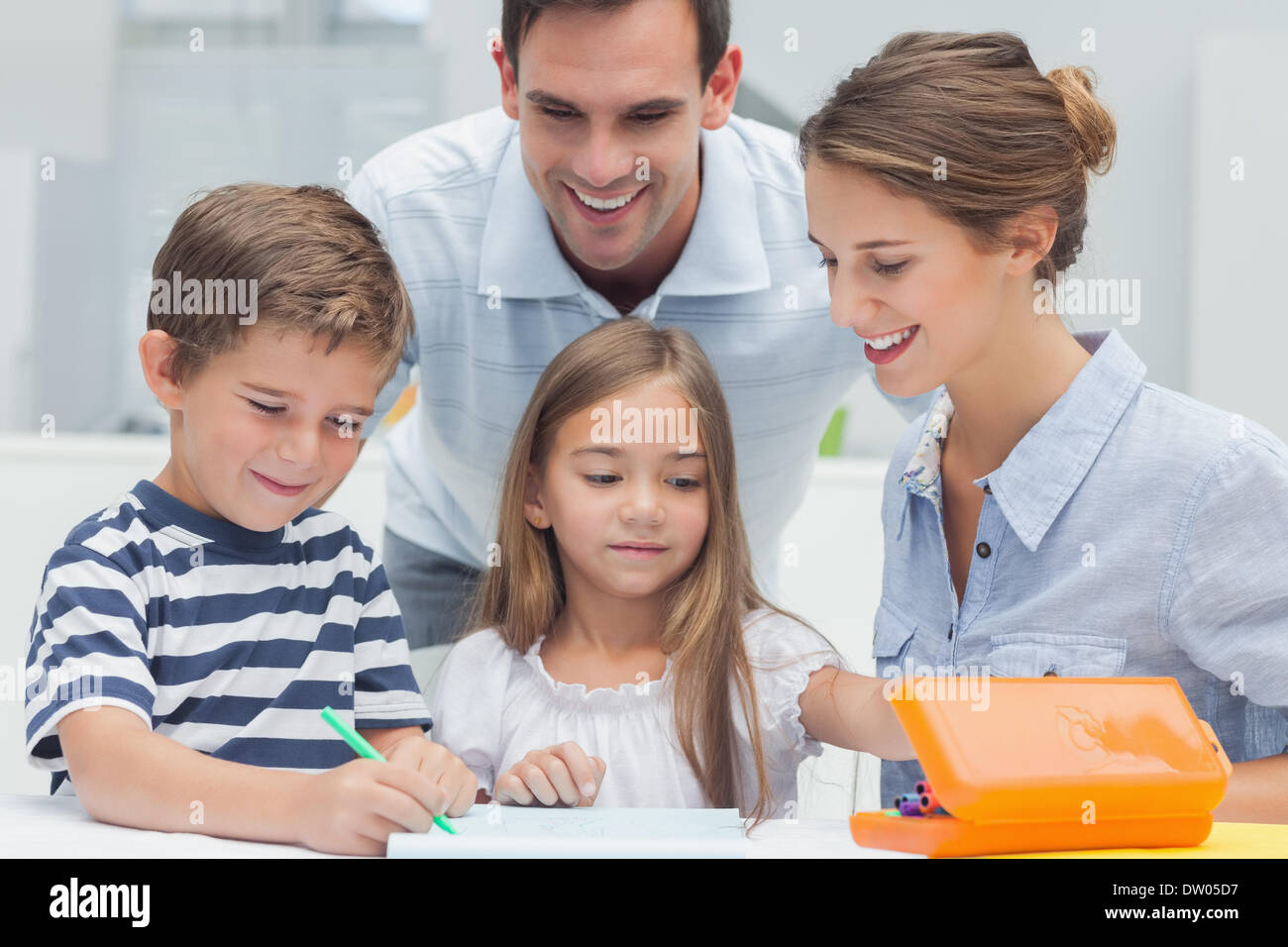 Parents looking at their children drawing Stock Photo - Alamy