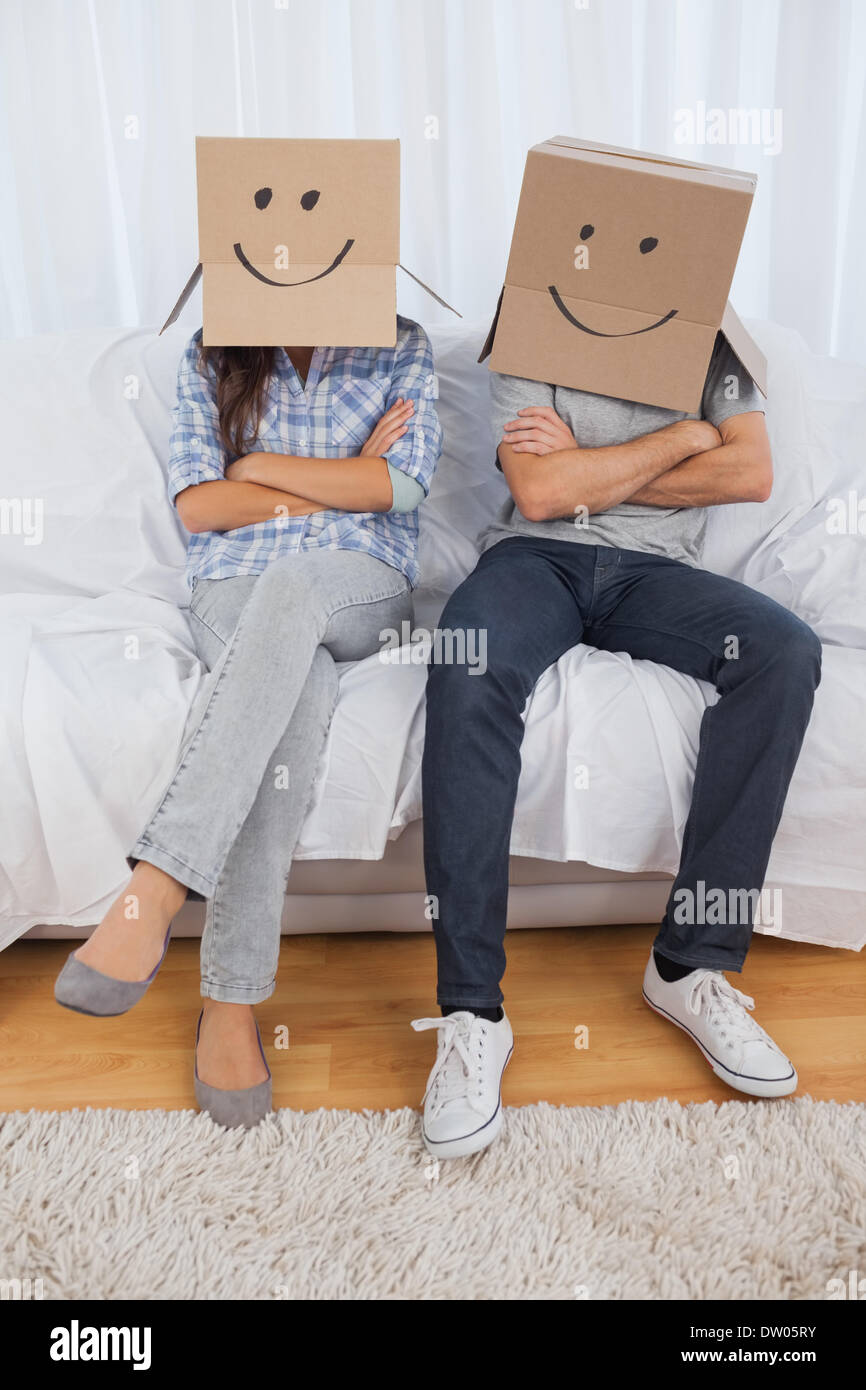 Couple sitting with cardboard boxes on head Stock Photo - Alamy