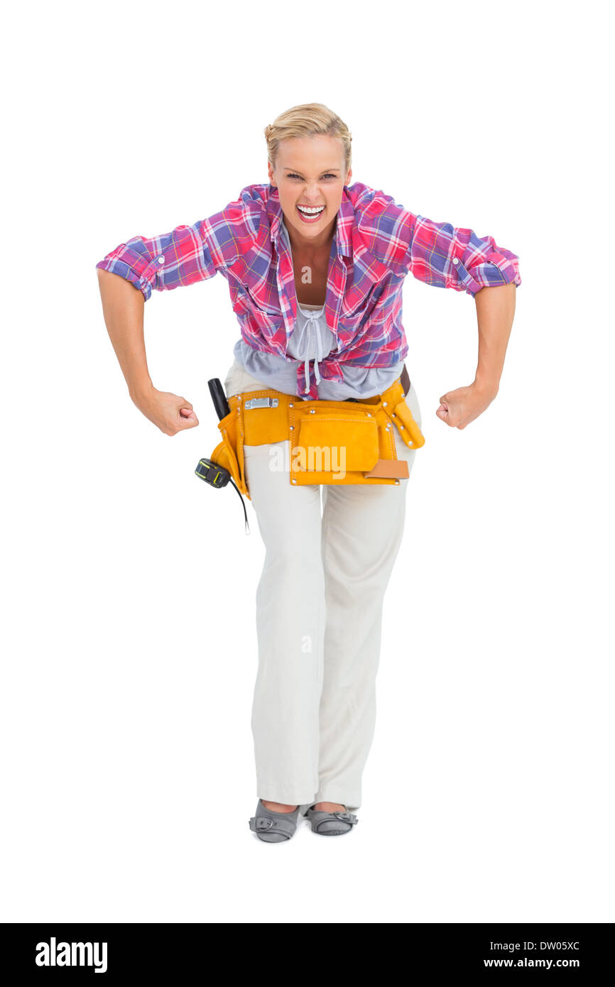 Blonde woman tensing arms wearing tool belt Stock Photo - Alamy