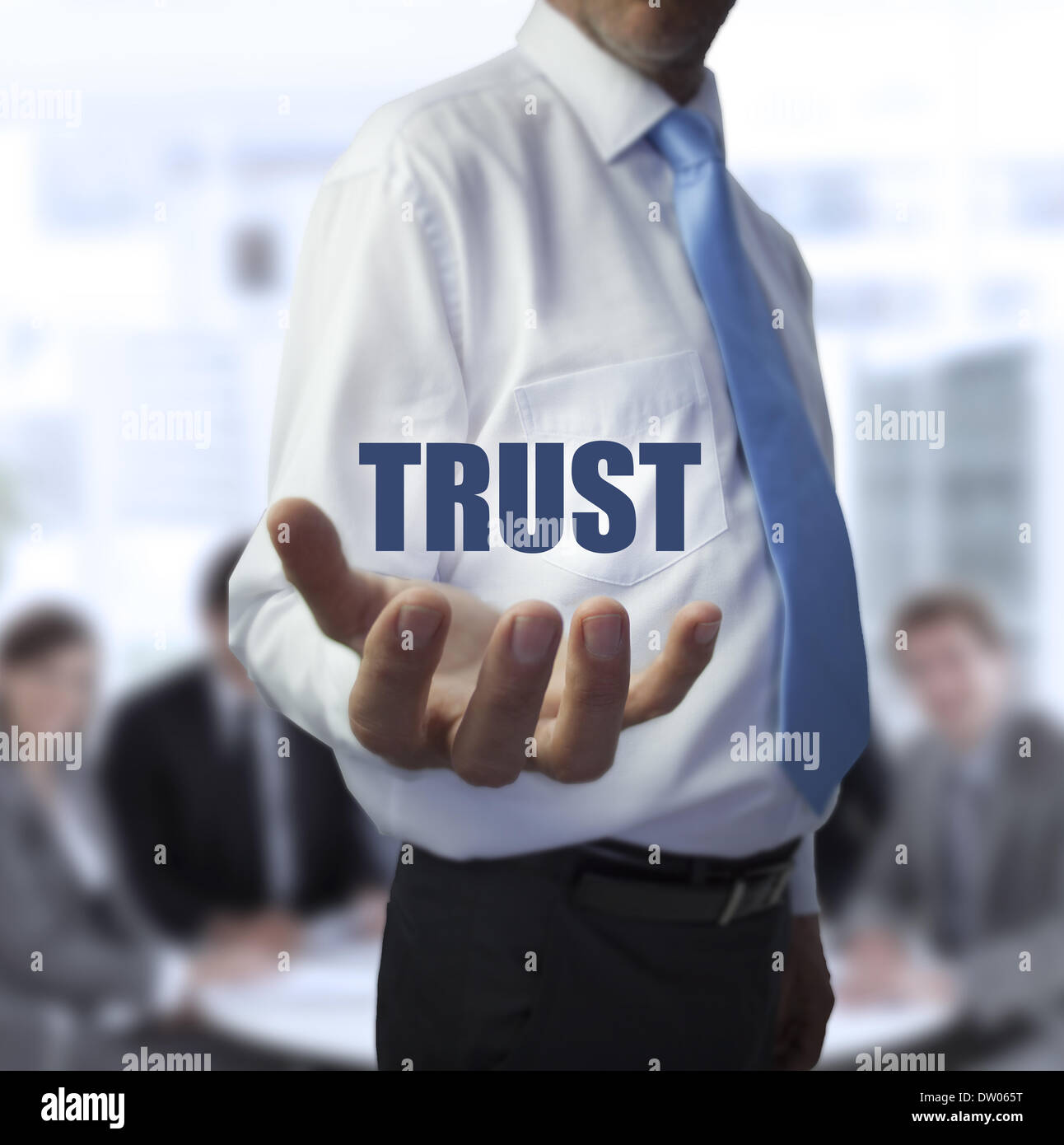 Elegant businessman holding the word trust Stock Photo - Alamy
