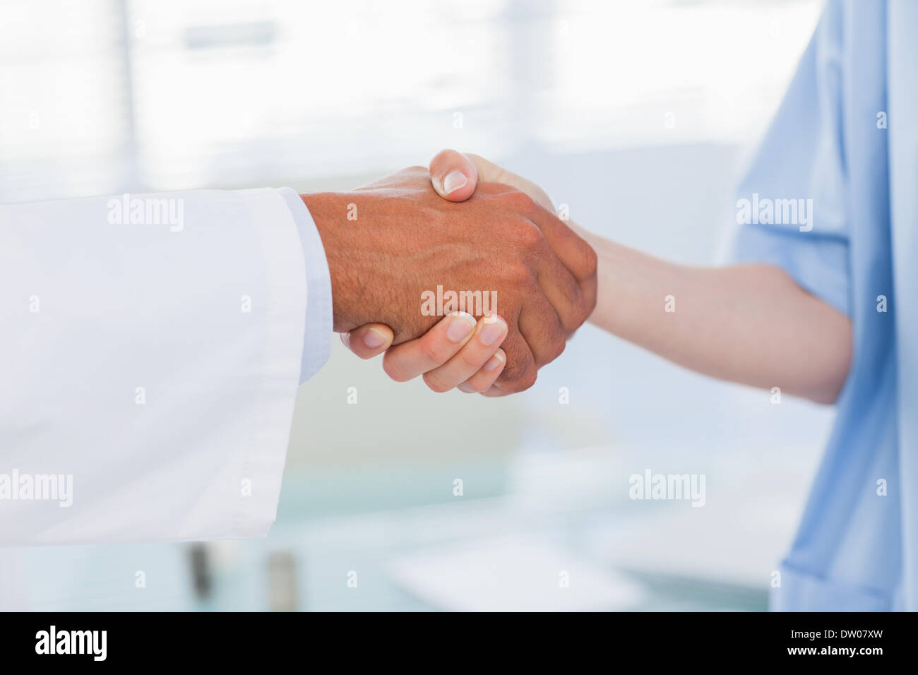 Hands of a doctor and nurse shaking hands Stock Photo - Alamy