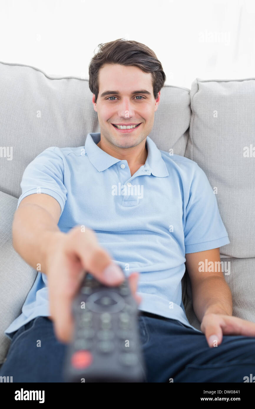 Portrait of a cheerful man changing channel Stock Photo - Alamy