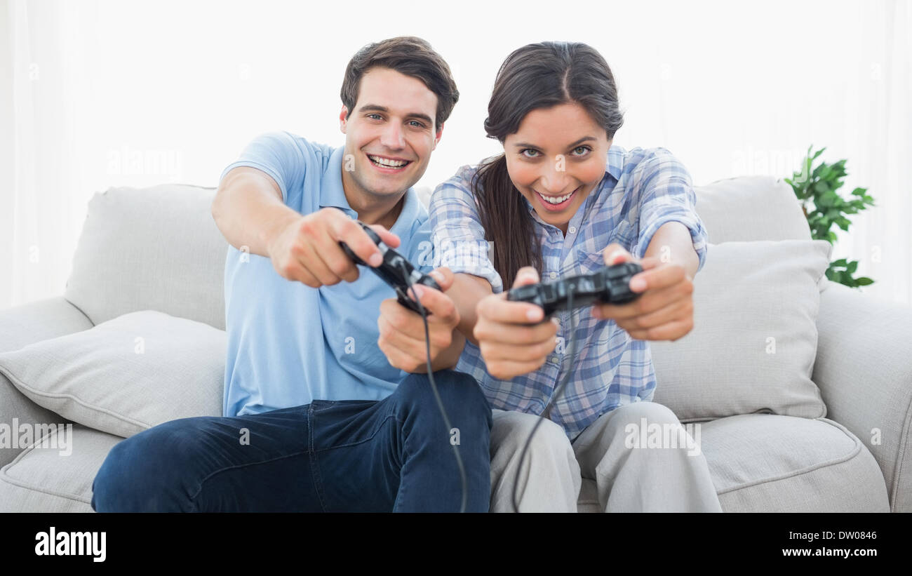 Couple playing video games on the couch Stock Photo - Alamy