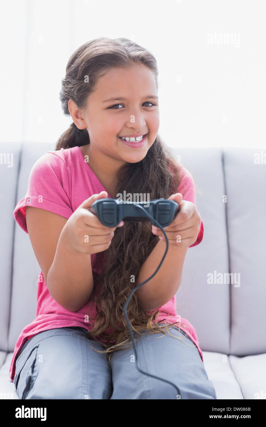 Little girl playing video game on sofa Stock Photo - Alamy