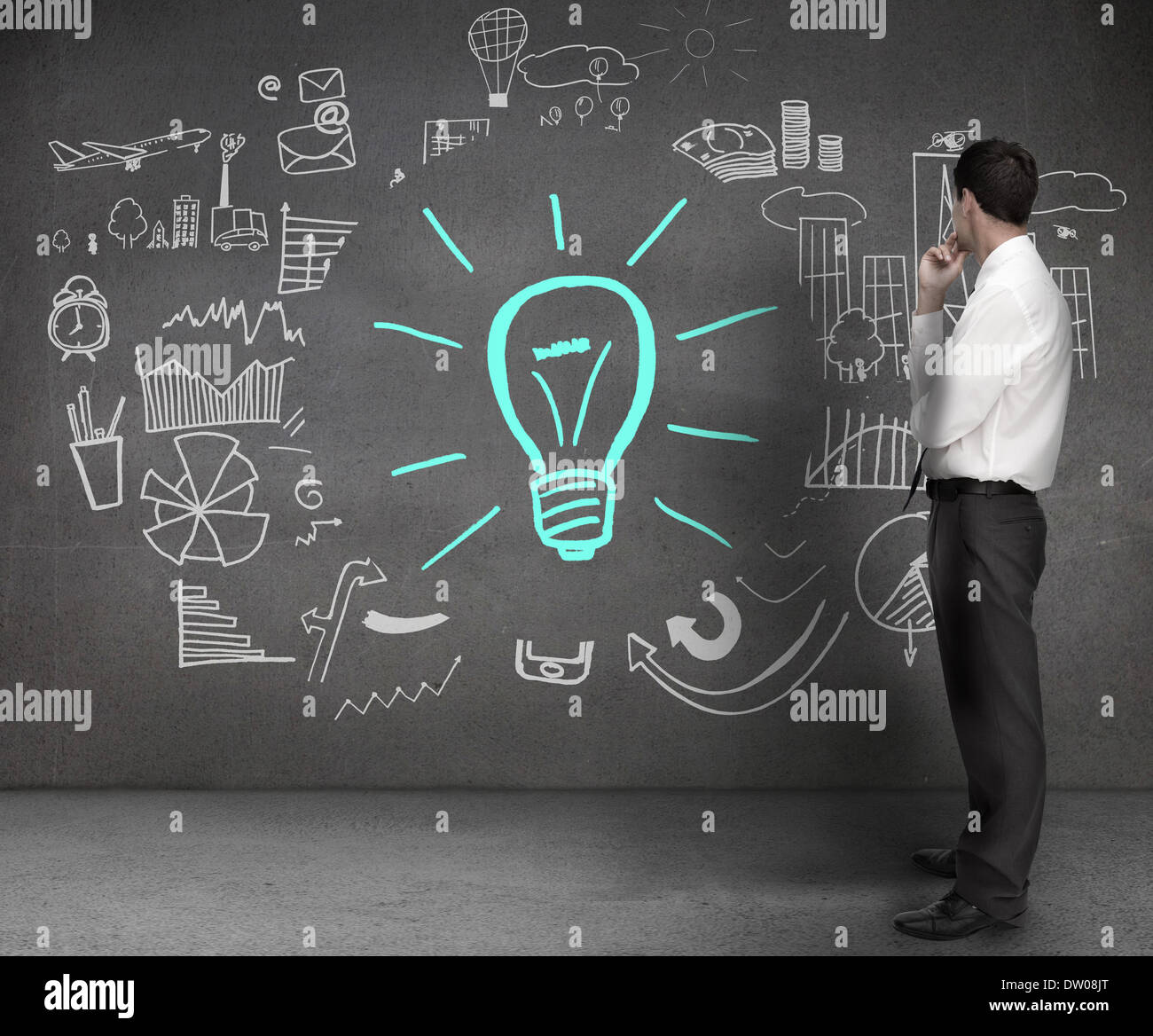 Businessman looking at drawings on a wall Stock Photo - Alamy