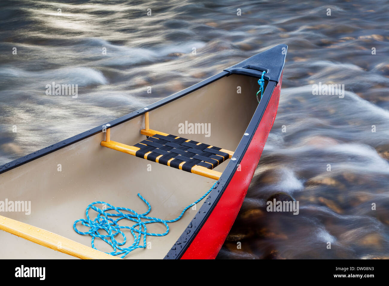 red canoe stern with a rope against river rapid Stock Photo - Alamy