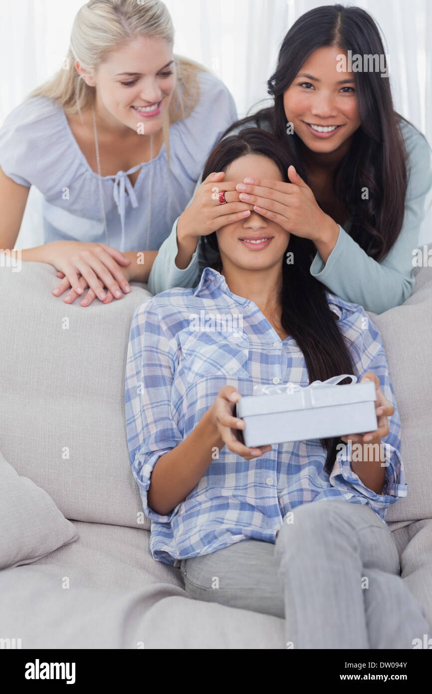 Friends surprising brunette with a gift Stock Photo - Alamy