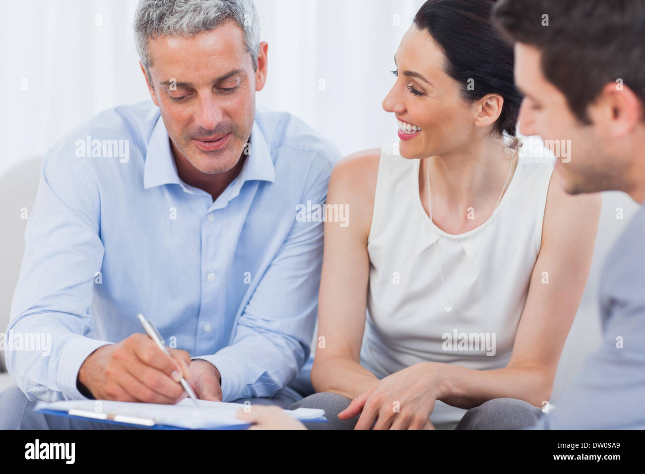 Client signing a contract with wife Stock Photo - Alamy