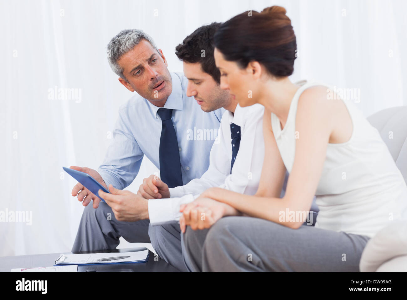 Business people talking about files on sofa Stock Photo - Alamy