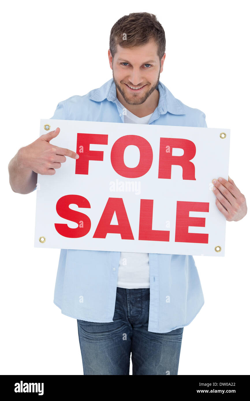 Smiling model holding a for sale sign Stock Photo - Alamy