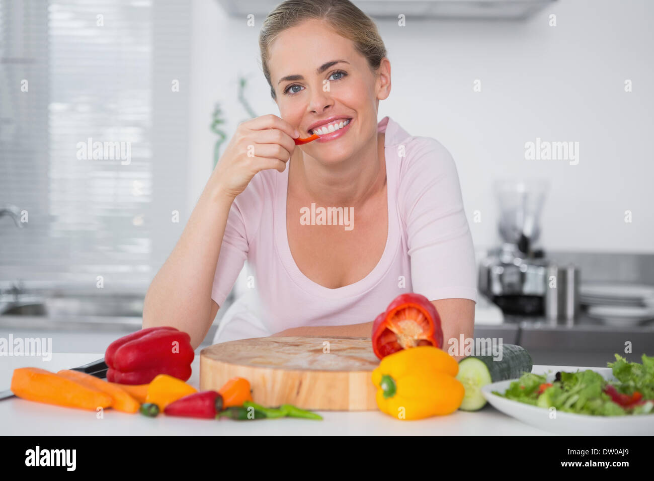 Blonde woman eating piece pepper hi-res stock photography and images ...