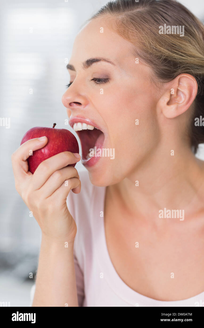 Pretty woman munching apple in close up Stock Photo - Alamy