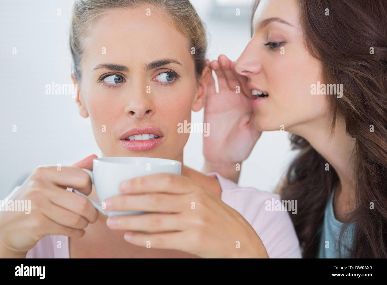Woman telling secret to her friend Stock Photo - Alamy