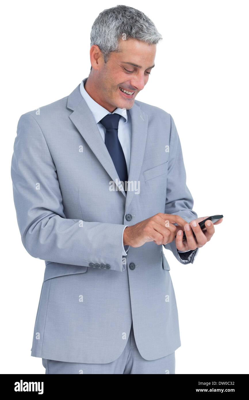 Cheerful businessman sending text message Stock Photo - Alamy