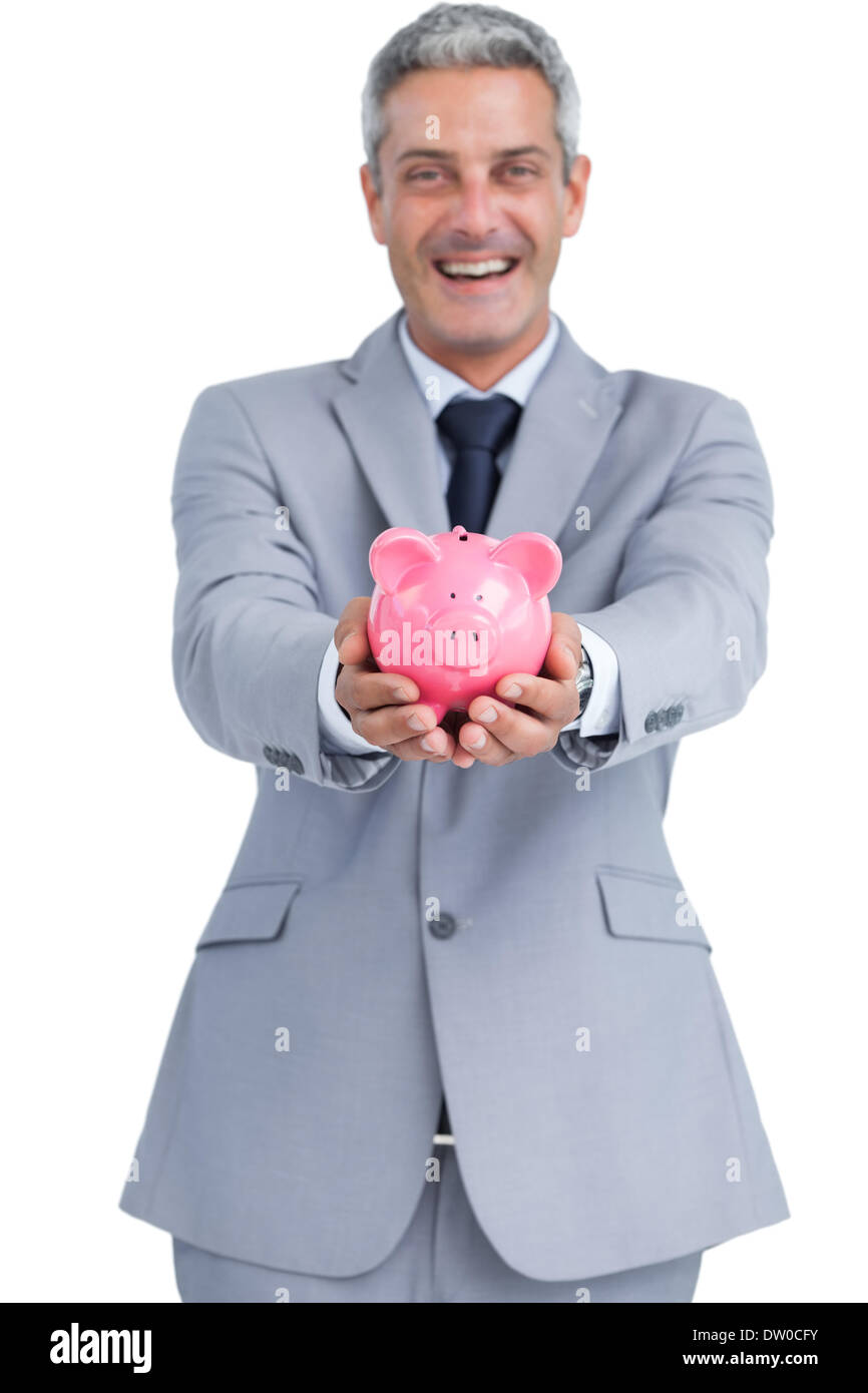 Wide smiling businessman holding piggy bank Stock Photo - Alamy