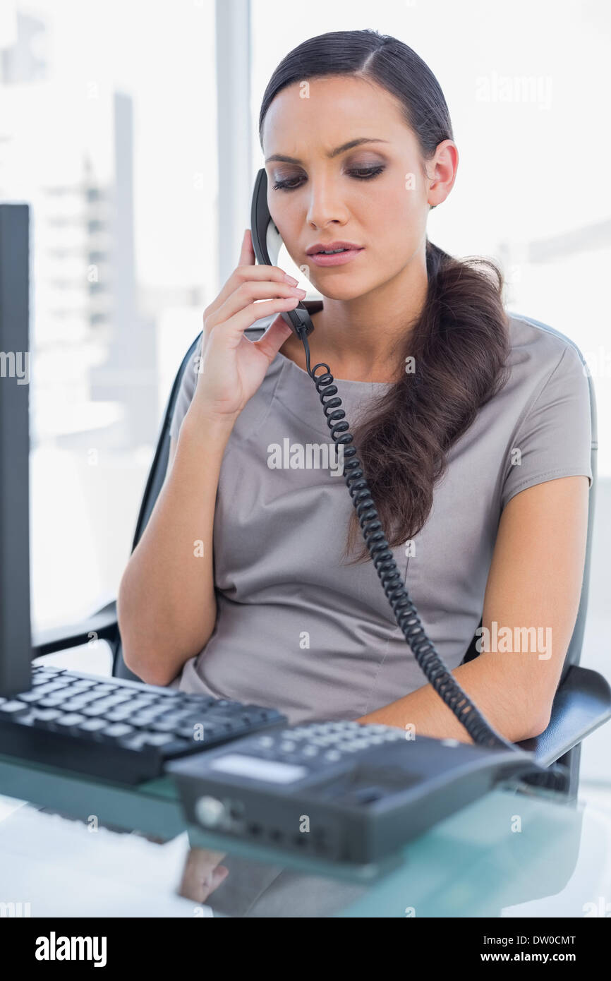 Serious secretary answering land line Stock Photo - Alamy