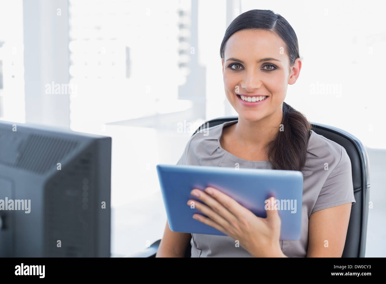 Cheerful attractive secretary using tablet pc Stock Photo - Alamy