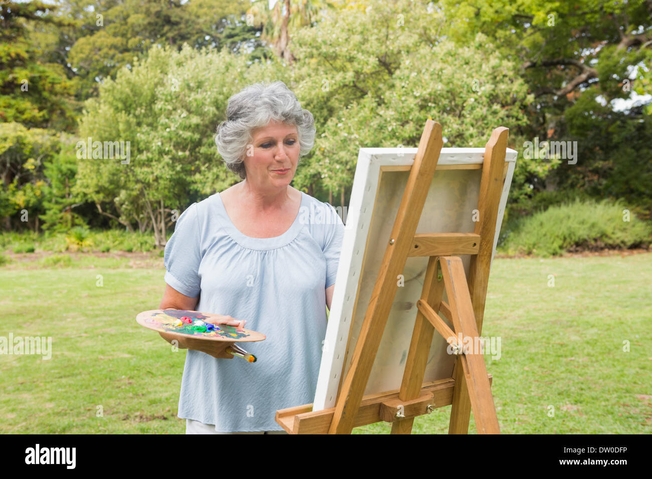 Happy mature woman painting on canvas Stock Photo - Alamy