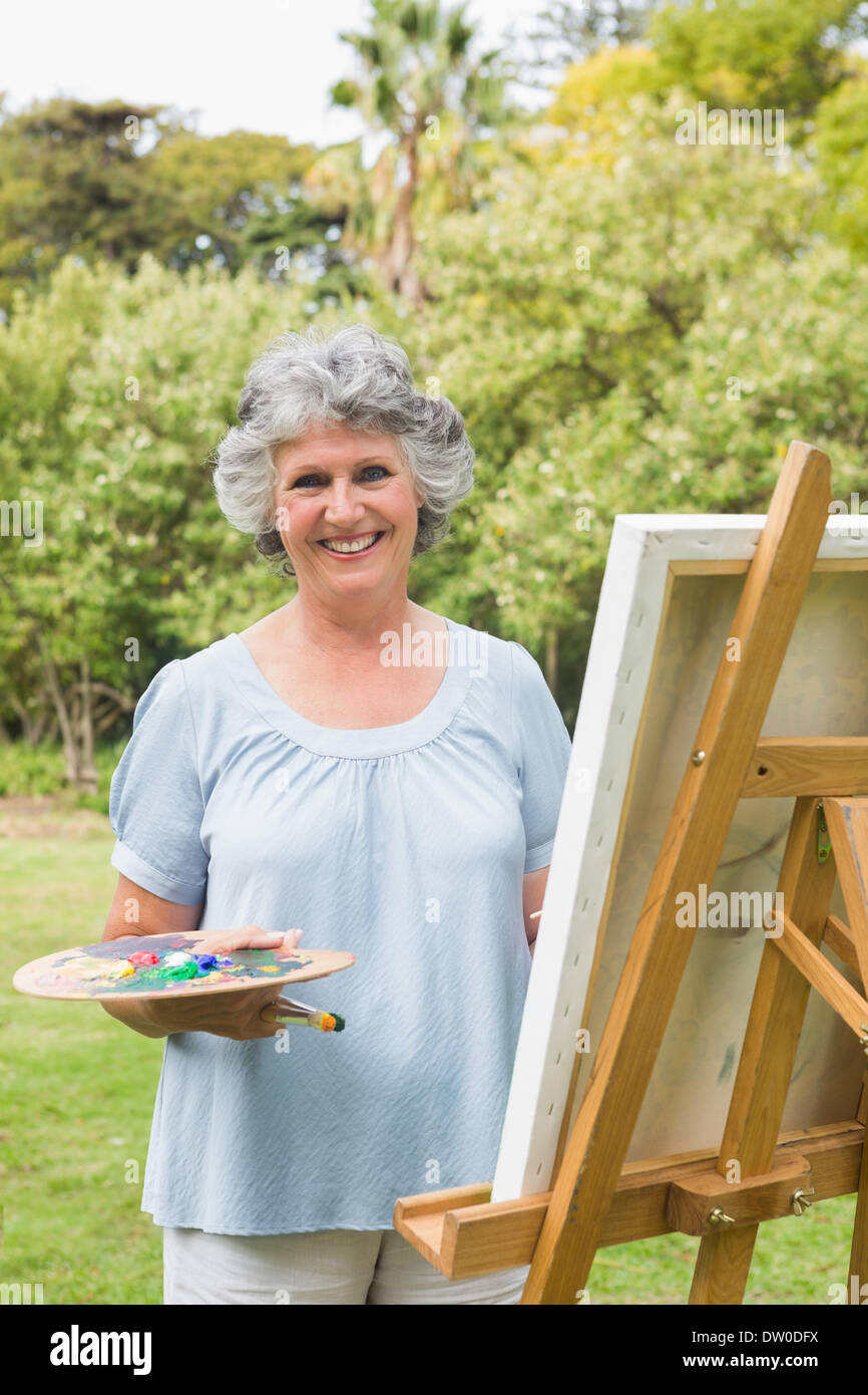 Smiling mature woman painting on canvas Stock Photo - Alamy
