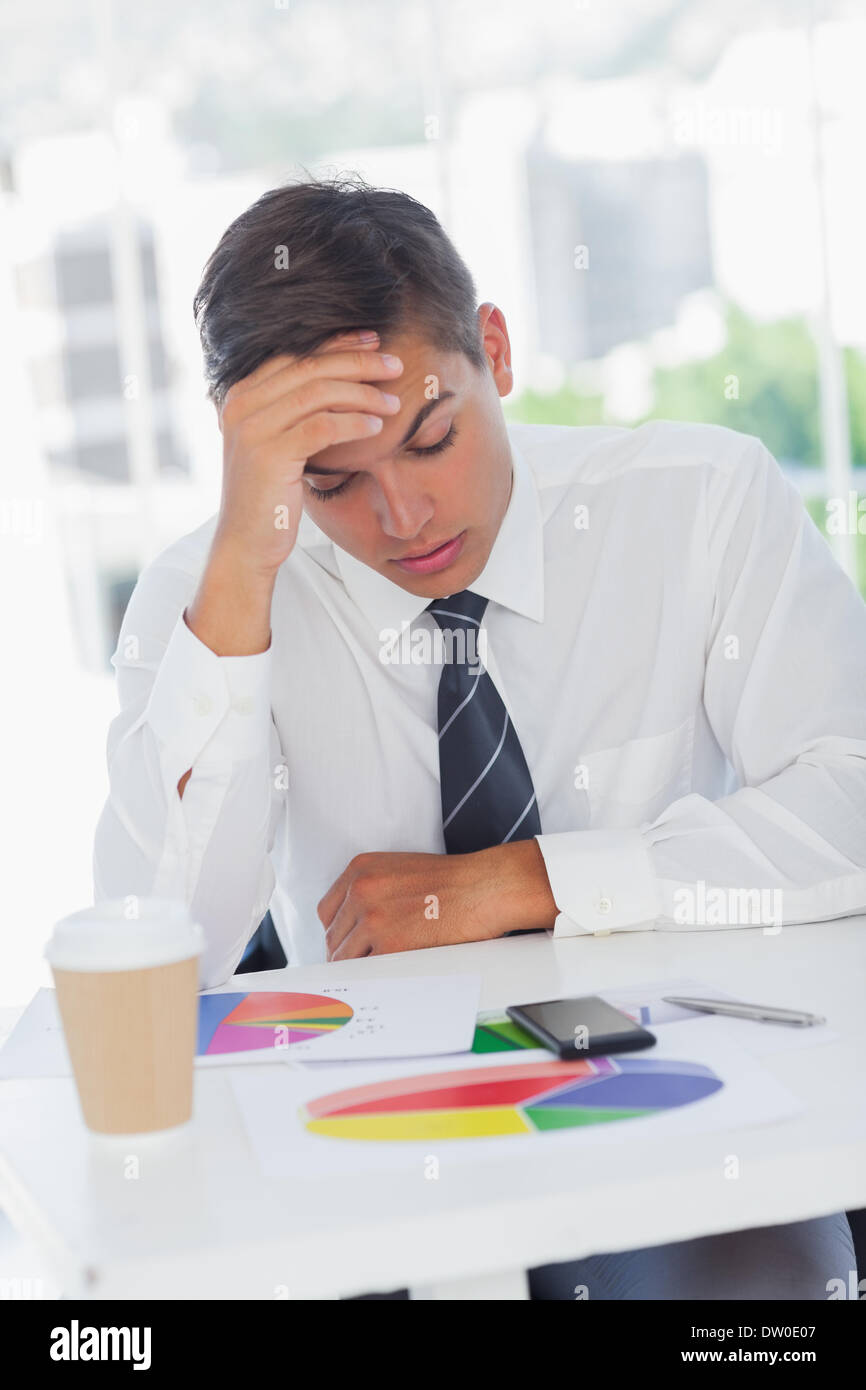 Bored young businessman analyzing graphs Stock Photo - Alamy