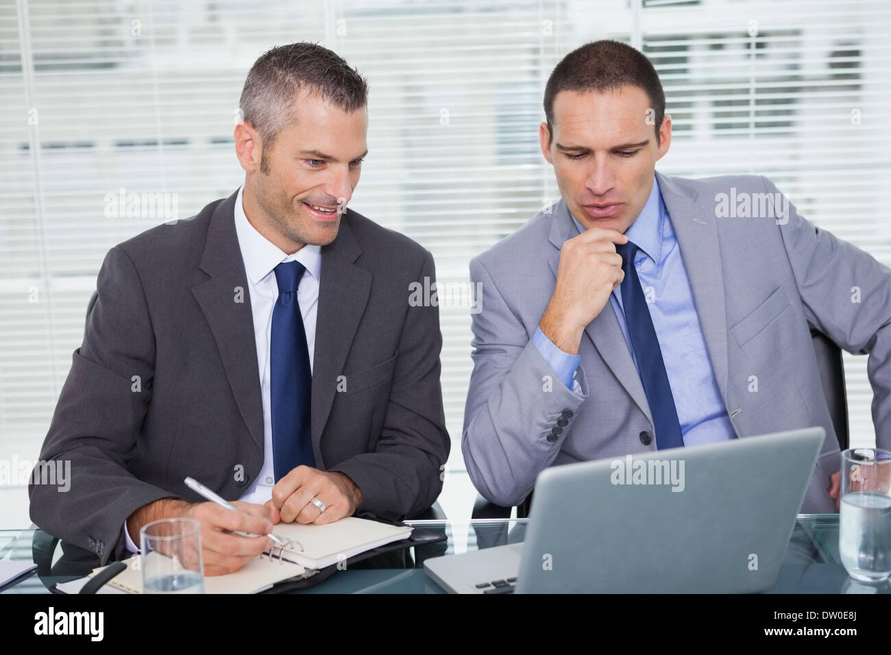 Serious businessmen analyzing application Stock Photo - Alamy
