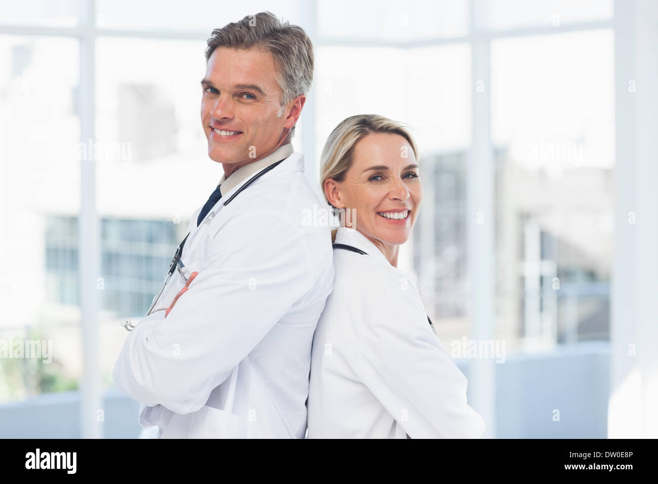 Smiling doctors posing together back to back Stock Photo - Alamy