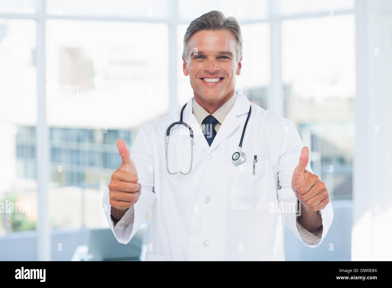 Experienced doctor posing thumbs up Stock Photo - Alamy