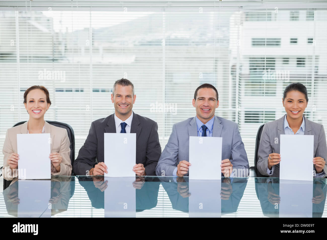 Smiling interview panel holding white paper Stock Photo - Alamy