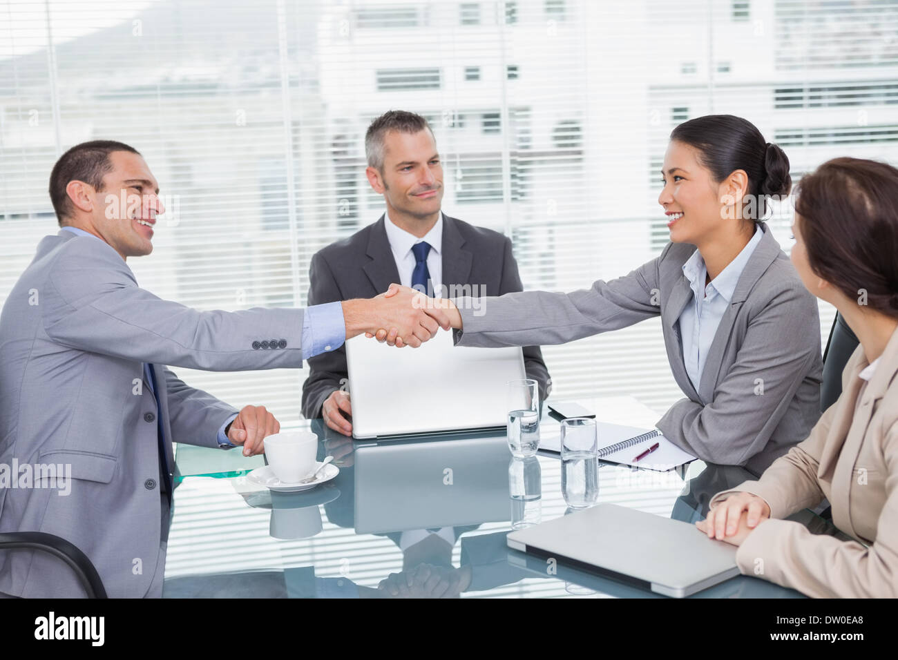 Smiling business people shaking hands Stock Photo - Alamy