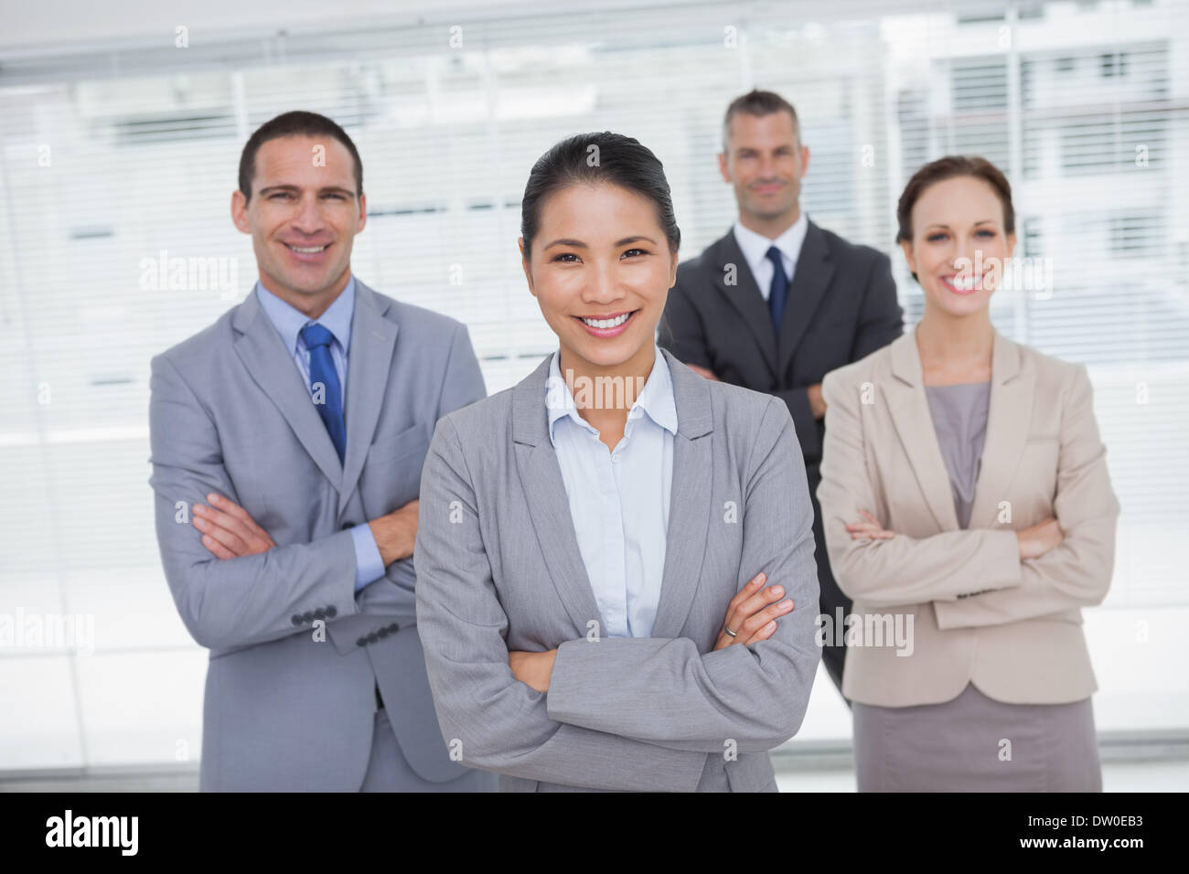 Cheerful work team posing crossing arms Stock Photo - Alamy