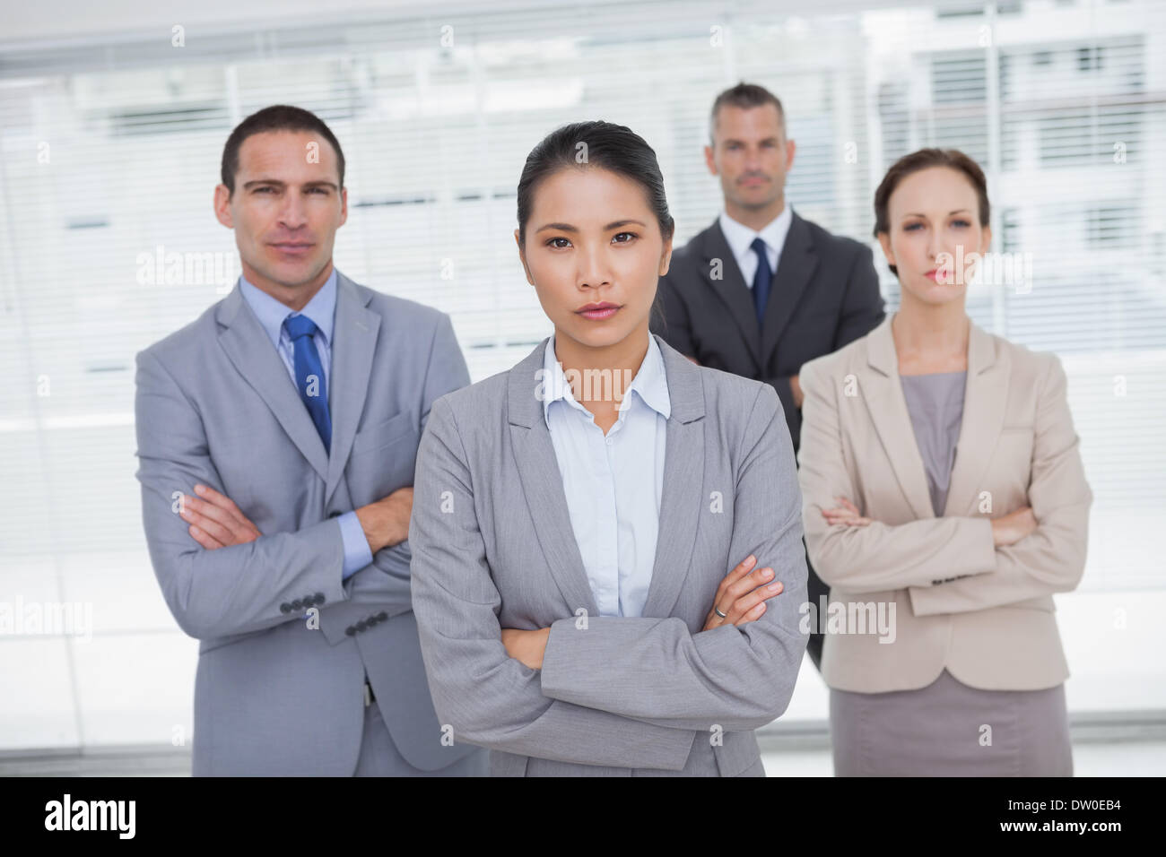 Serious work team posing crossing arms Stock Photo - Alamy
