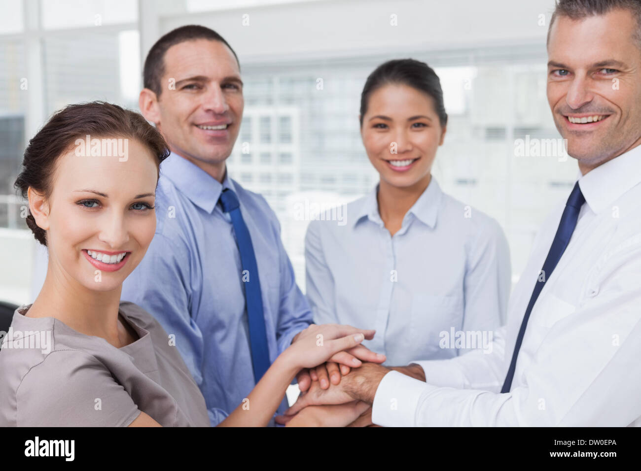 Cheerful work team joining hands together Stock Photo - Alamy