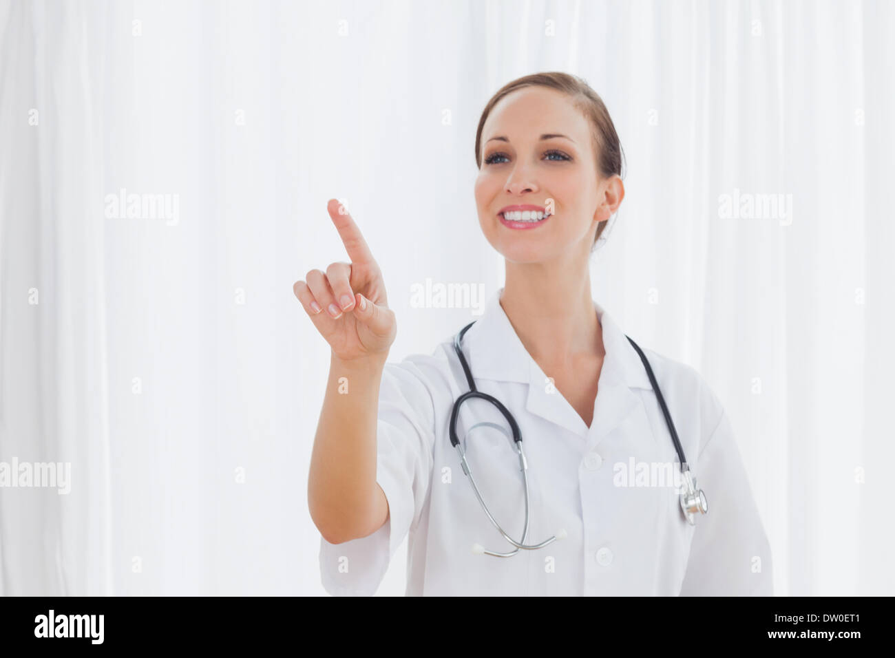 Smiling nurse posing pointing at something Stock Photo - Alamy