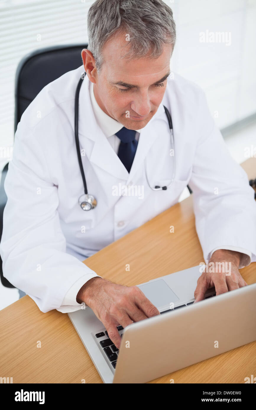 Experienced doctor typing on his laptop Stock Photo - Alamy