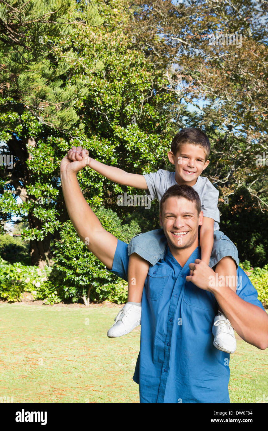 Son sitting on his fathers shoulders Stock Photo - Alamy