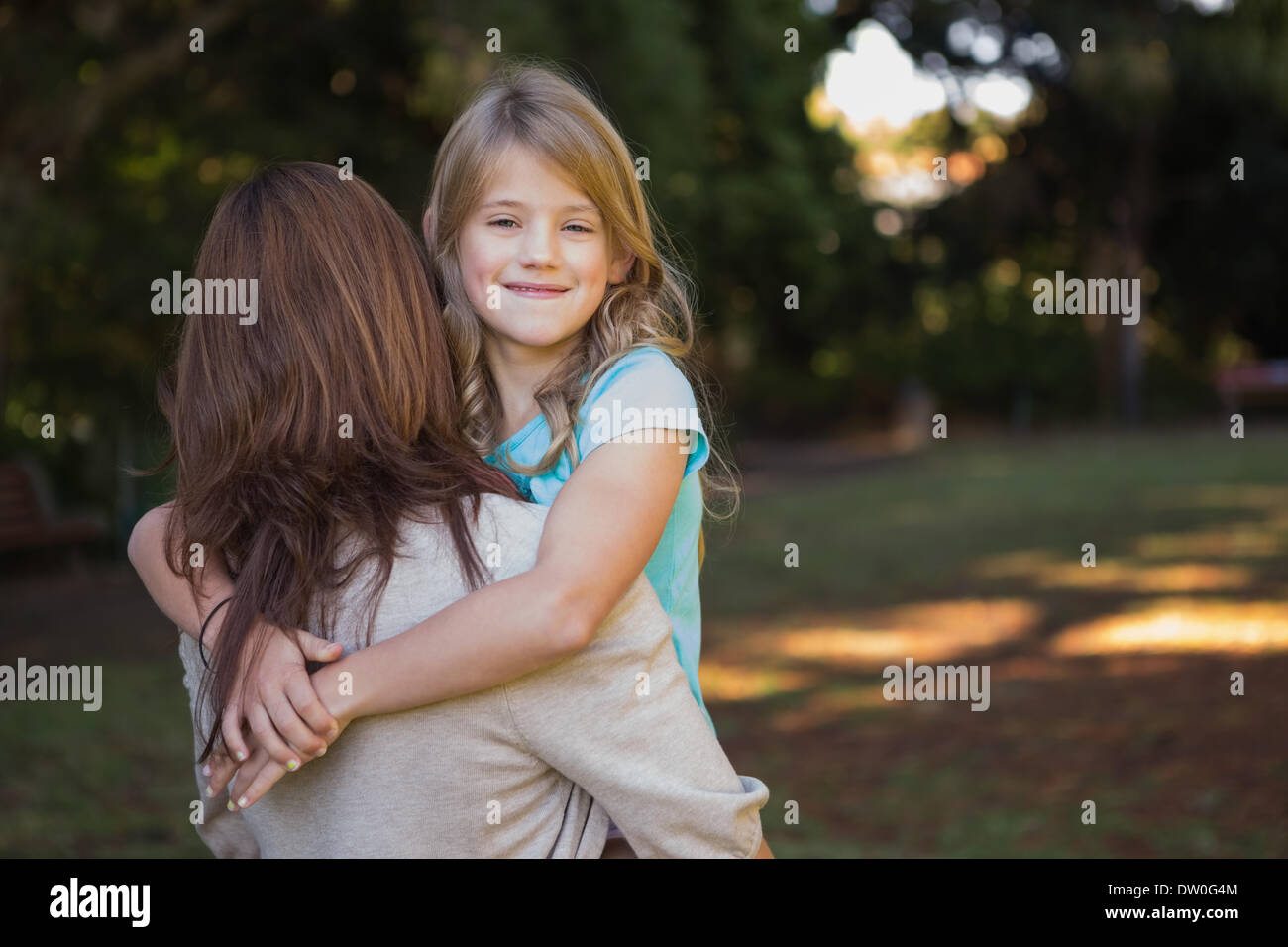 Child looking over her mothers shoulder Stock Photo - Alamy
