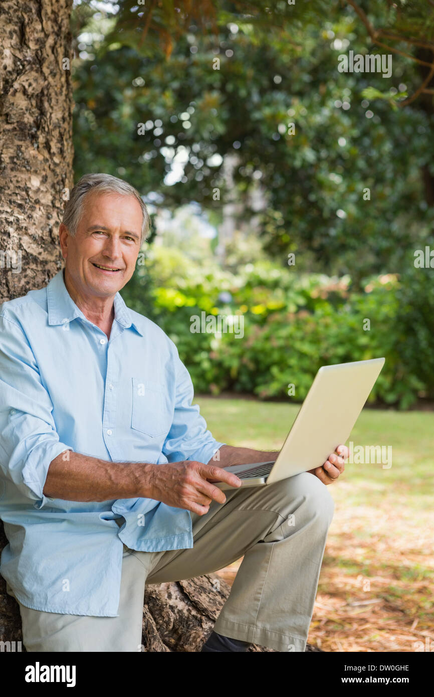 Man sitting against tree trunk hi-res stock photography and images - Alamy