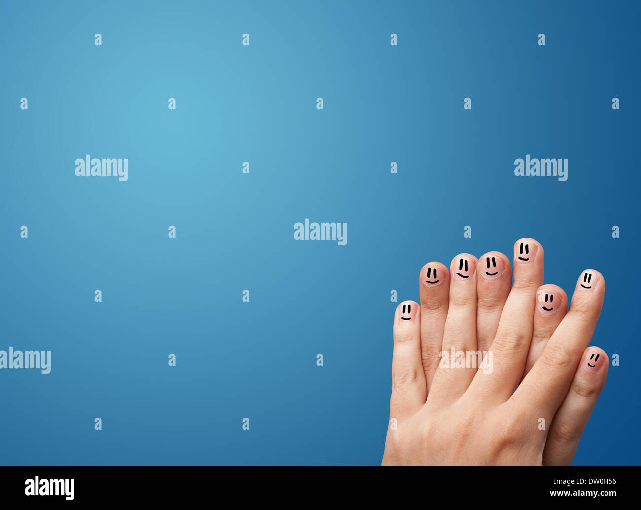Happy smiley face fingers looking at empty blue background copy space ...