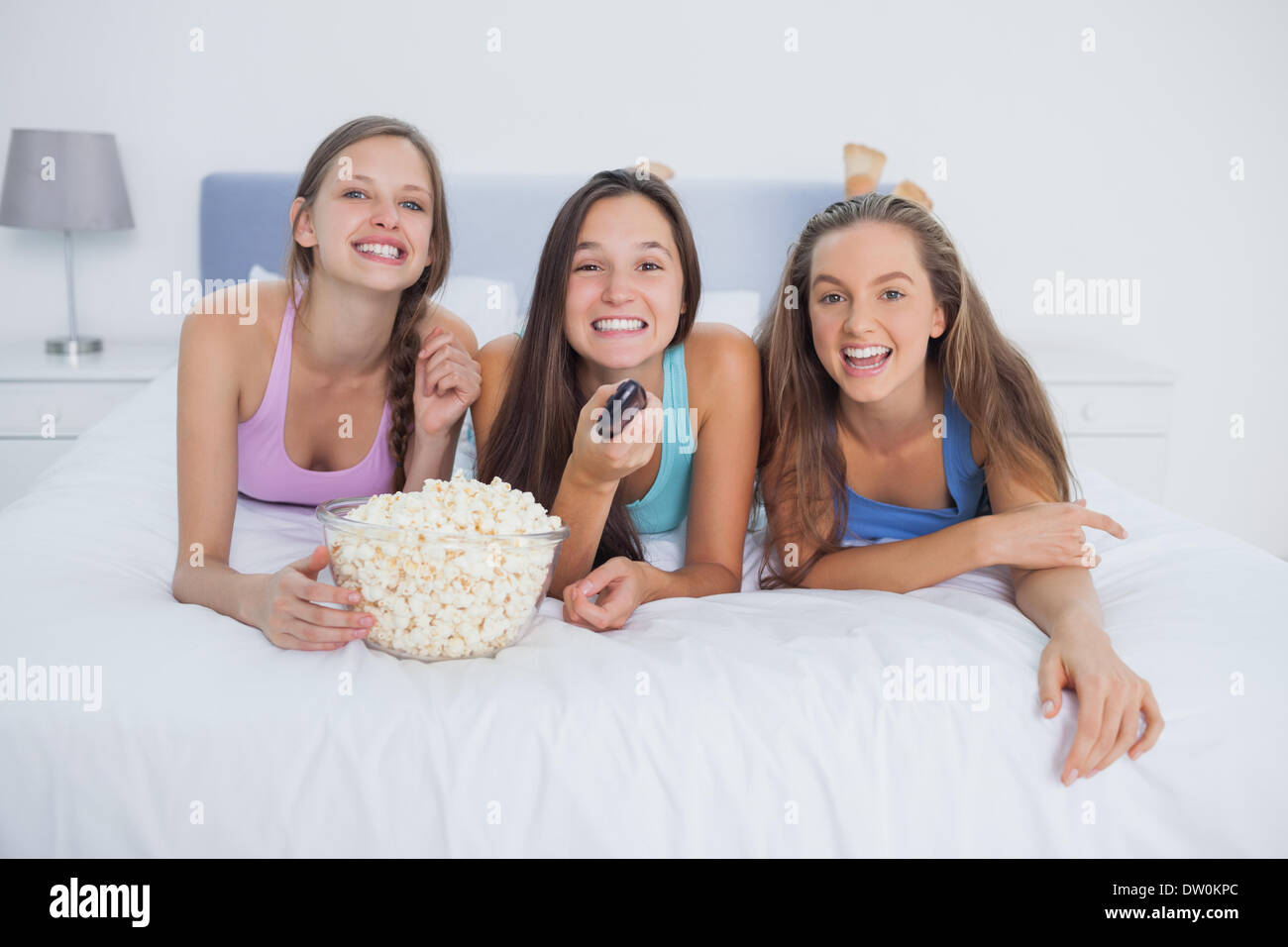 Friends eating popcorn and laughing Stock Photo - Alamy