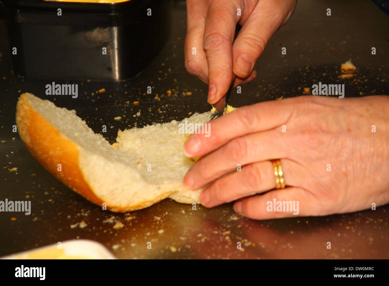 Woman buttering cut roll Stock Photo - Alamy