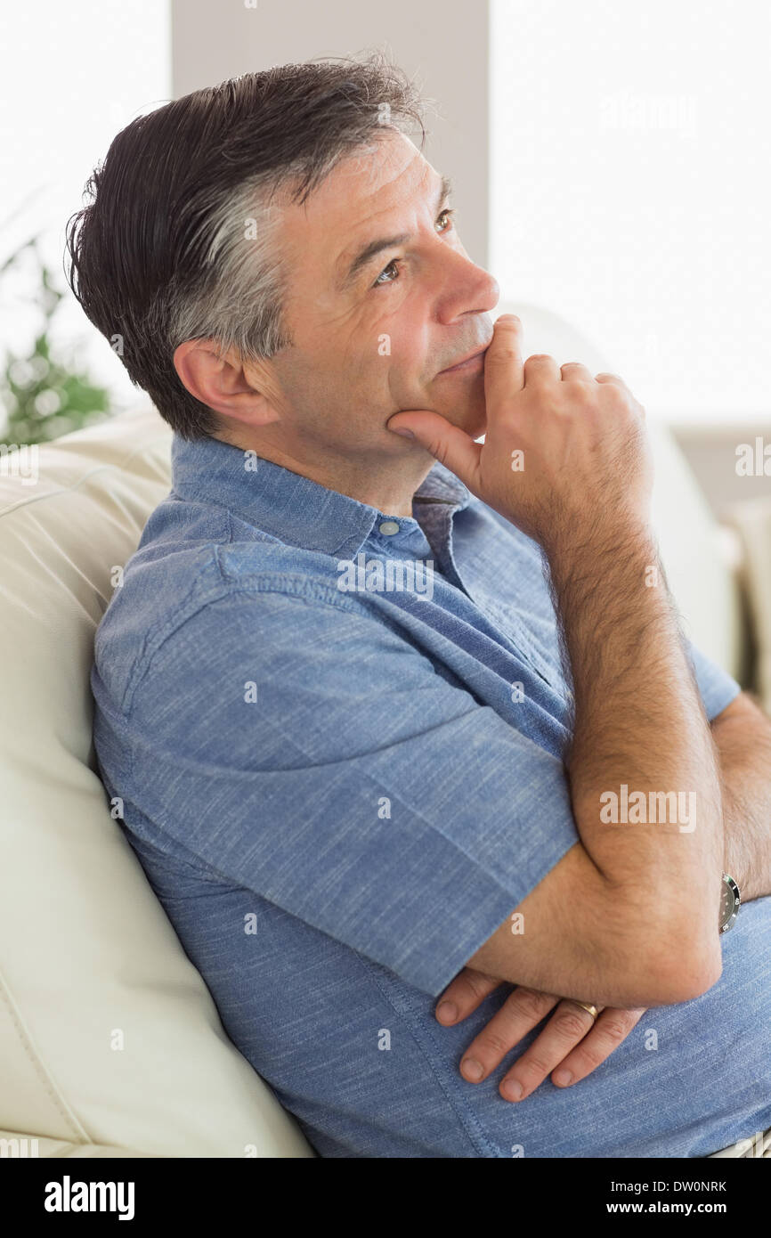 Thinking man sitting on sofa Stock Photo - Alamy