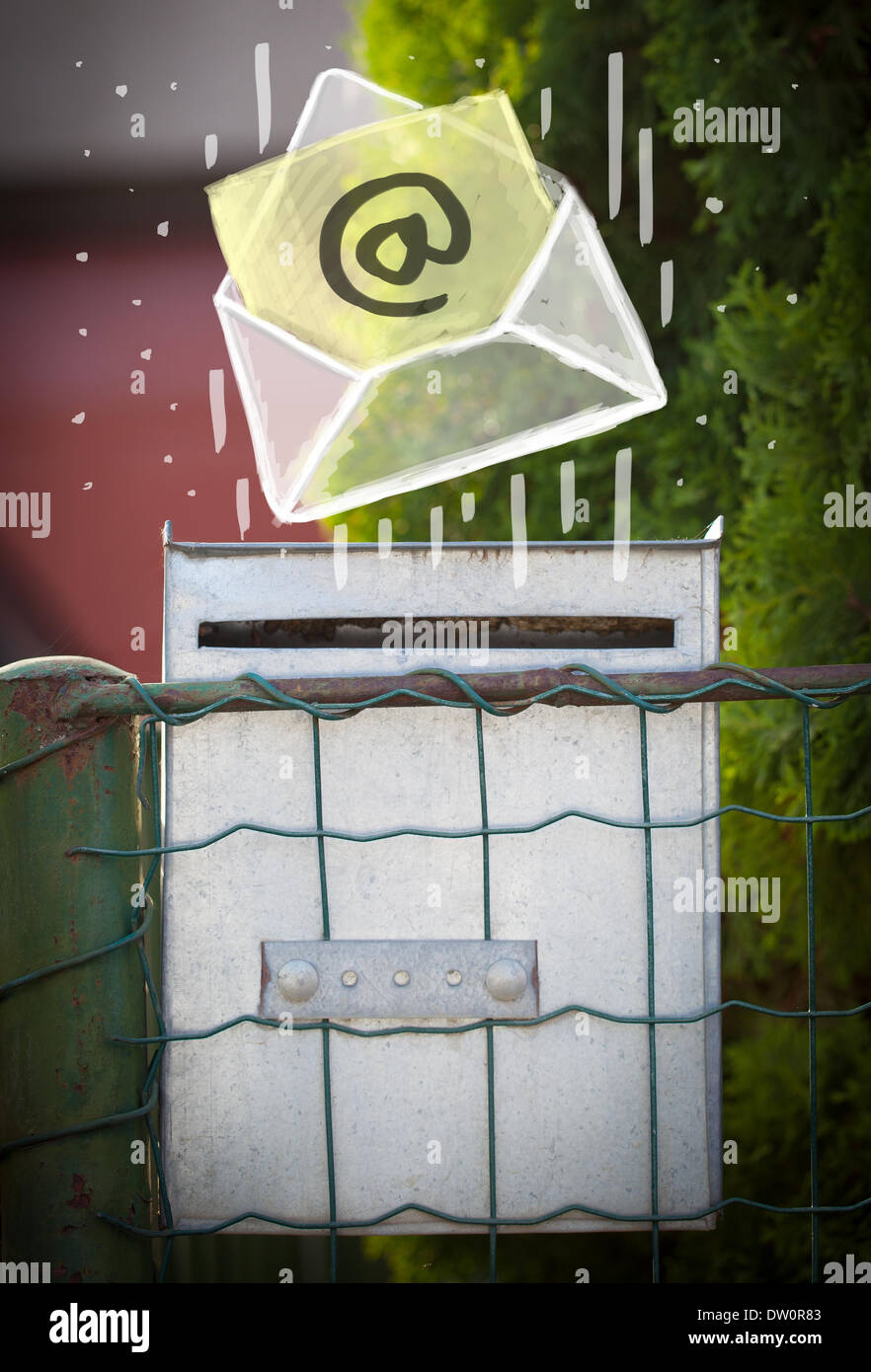 Envelope with email sign dropping into mailbox Stock Photo - Alamy