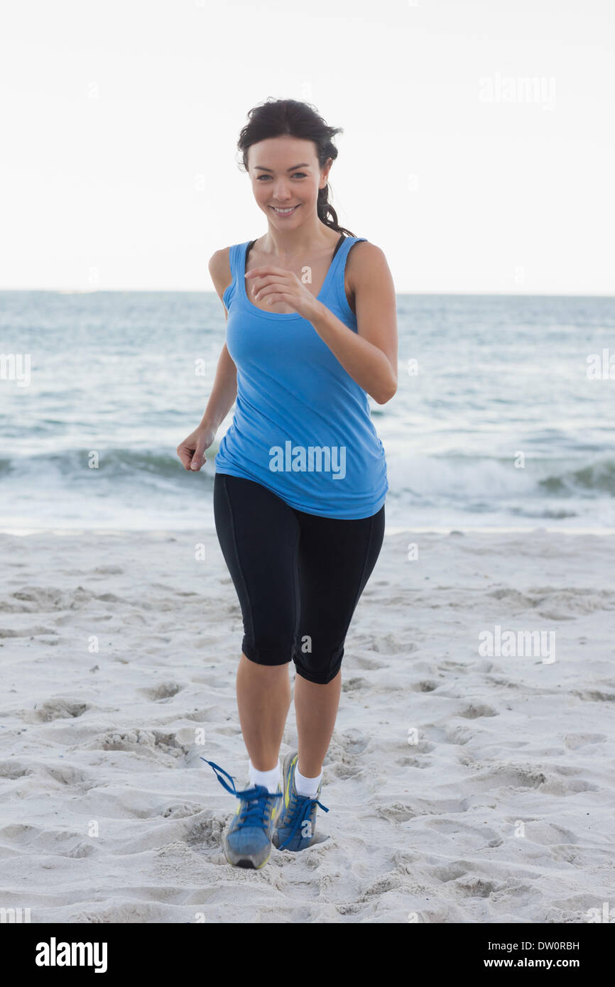 Sporty woman running at the beach Stock Photo - Alamy