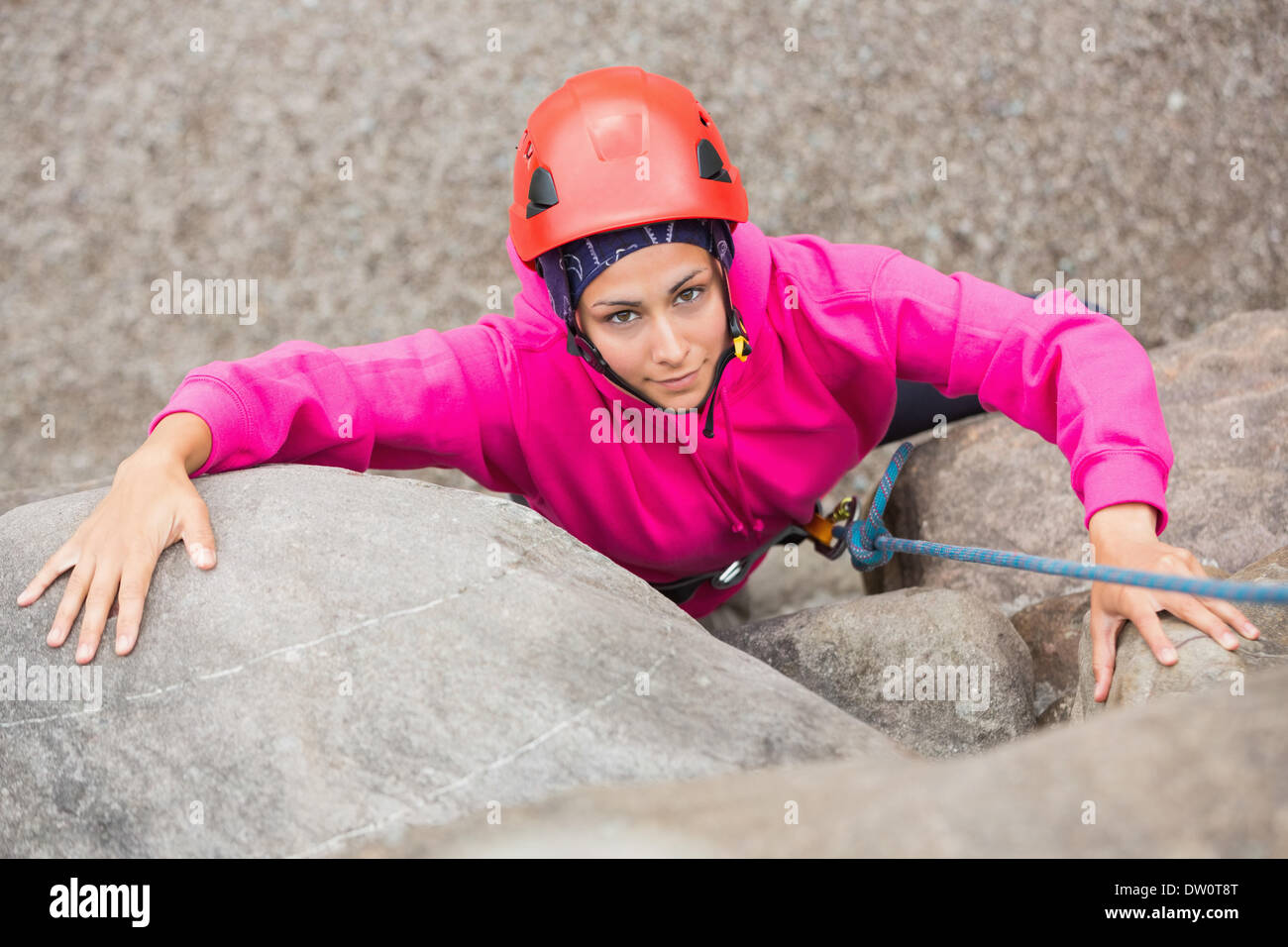 Smiling girl climbing up rock face Stock Photo - Alamy
