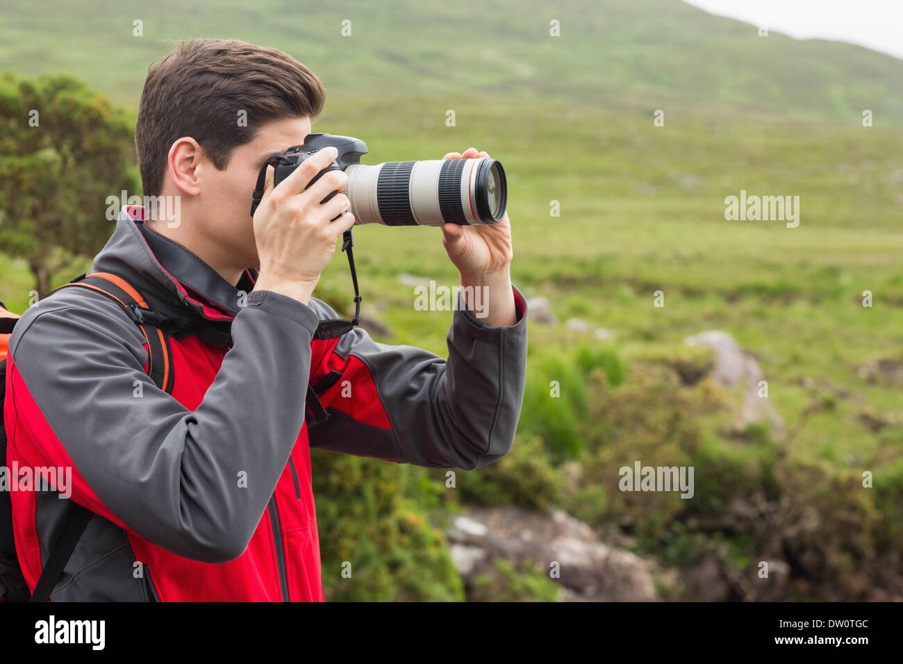 Handsome man on a hike taking a photograph Stock Photo - Alamy