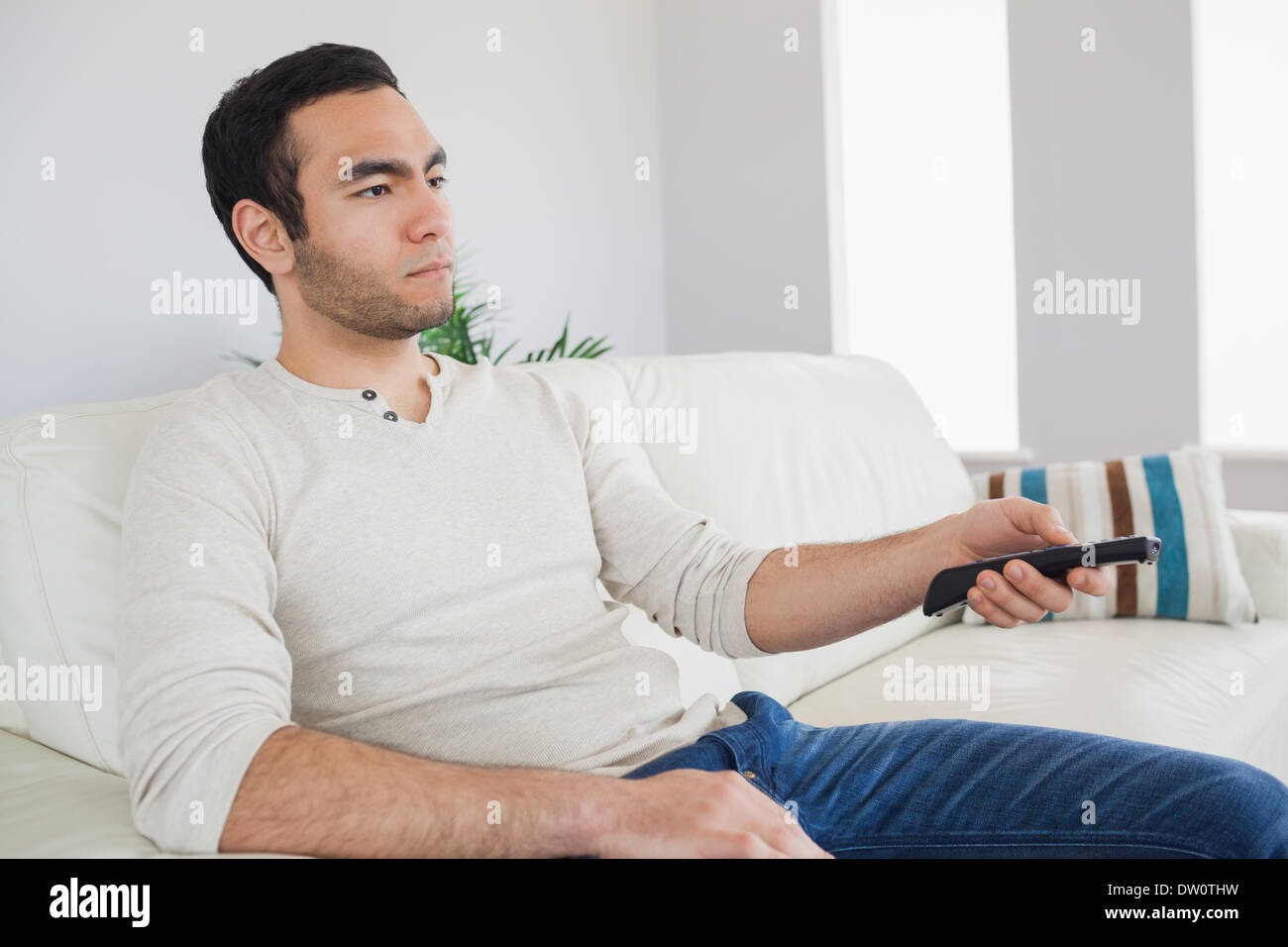 Serious man holding remote control Stock Photo - Alamy