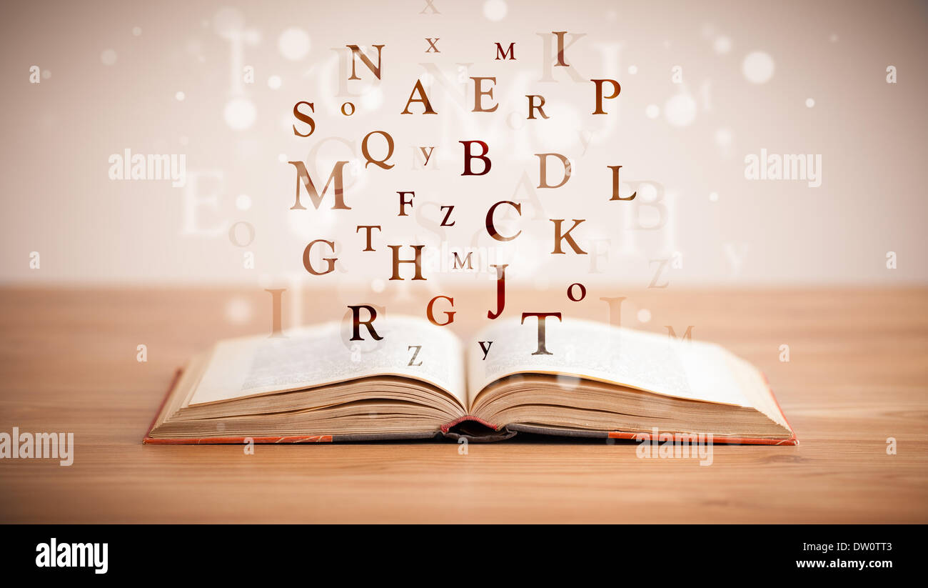 Opened book with flying letters Stock Photo - Alamy