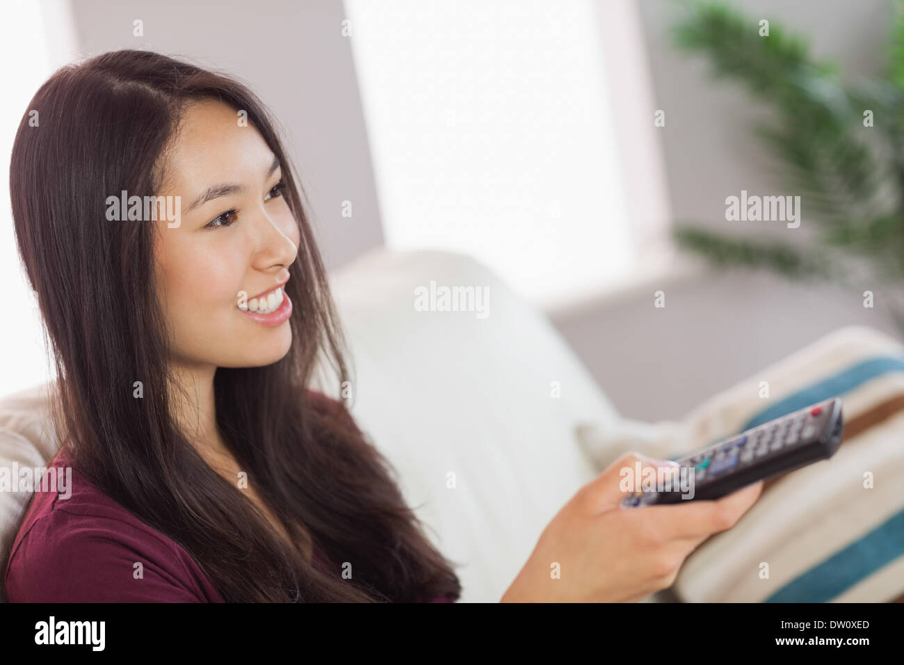 Pretty asian girl watching tv Stock Photo - Alamy
