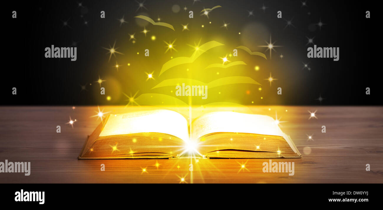 Open book with golden glow flying paper pages Stock Photo - Alamy