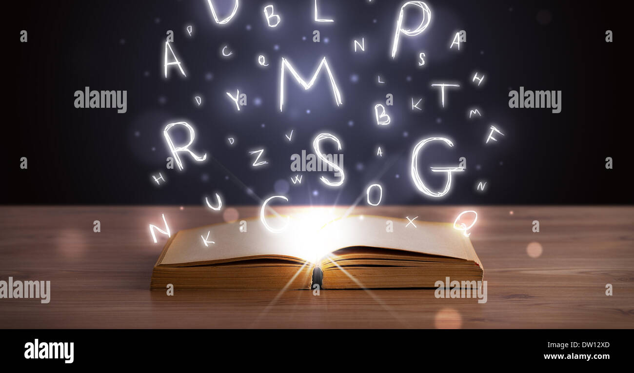 Open book with glowing letters flying out Stock Photo - Alamy